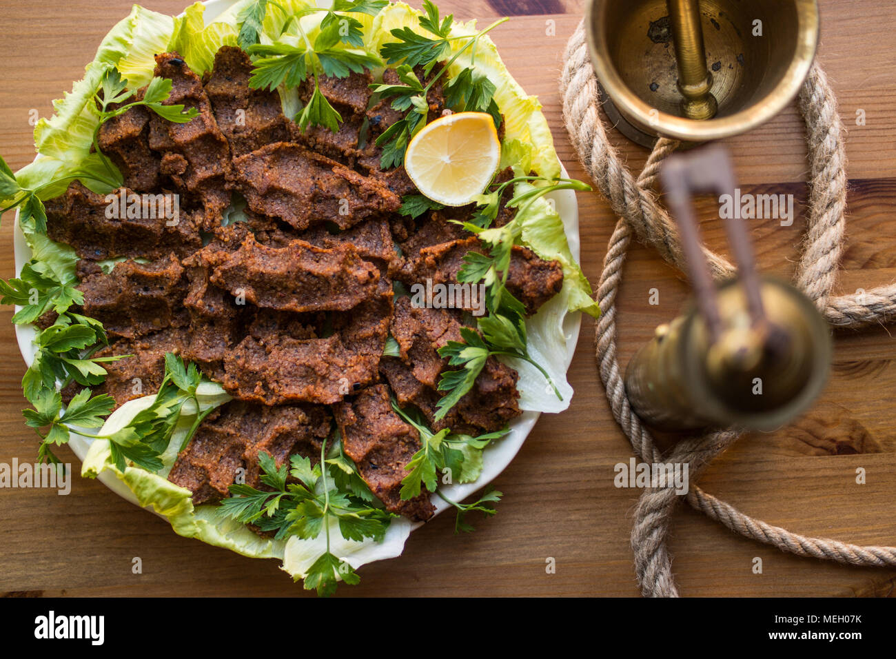Turkish Food Cig Kofte with lemon, lettuce and parsley on silver tray ...