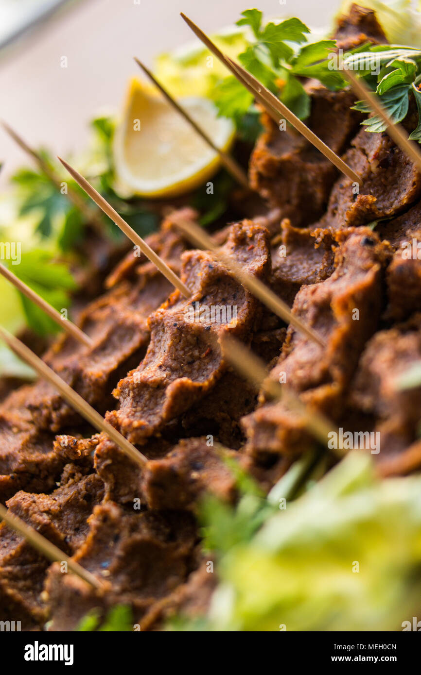 Turkish Food Cig Kofte with lemon, lettuce and parsley on silver tray ...