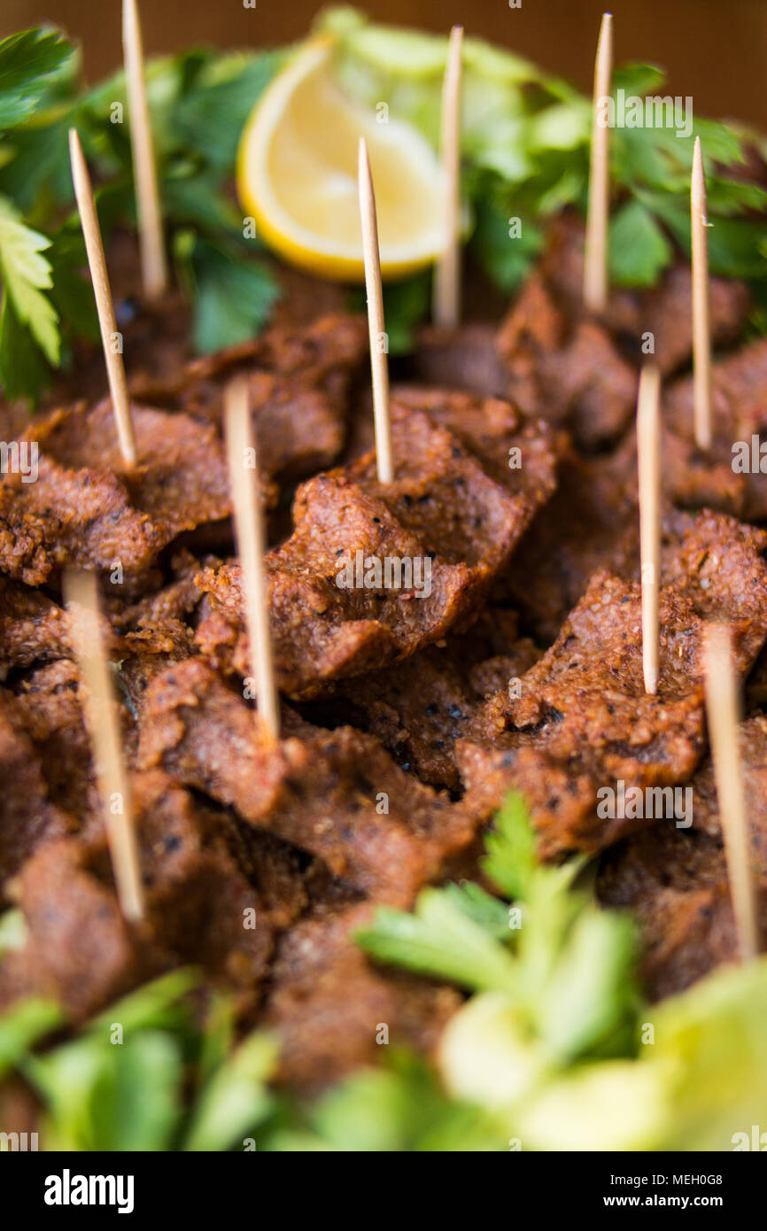 Turkish Food Cig Kofte with lemon, lettuce and parsley on silver tray ...