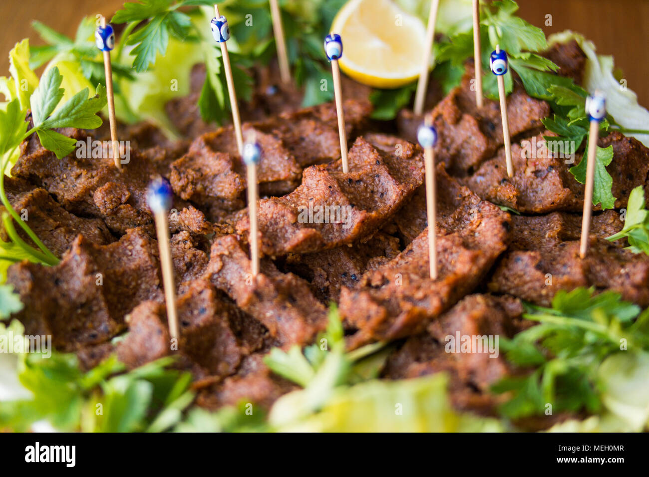 Turkish Food Cig Kofte with lemon, lettuce and parsley on silver tray ...