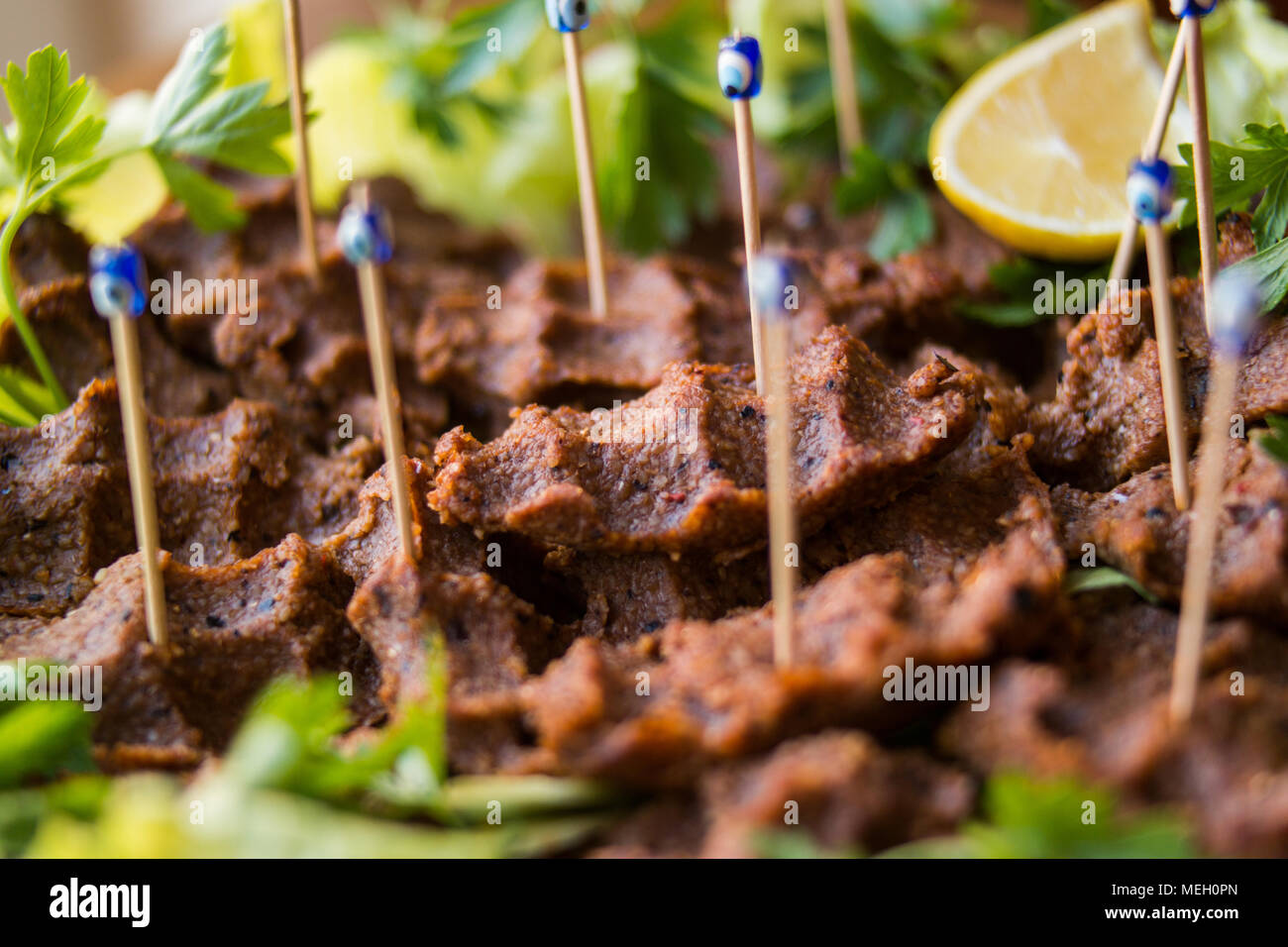 Turkish Food Cig Kofte with lemon, lettuce and parsley on silver tray ...