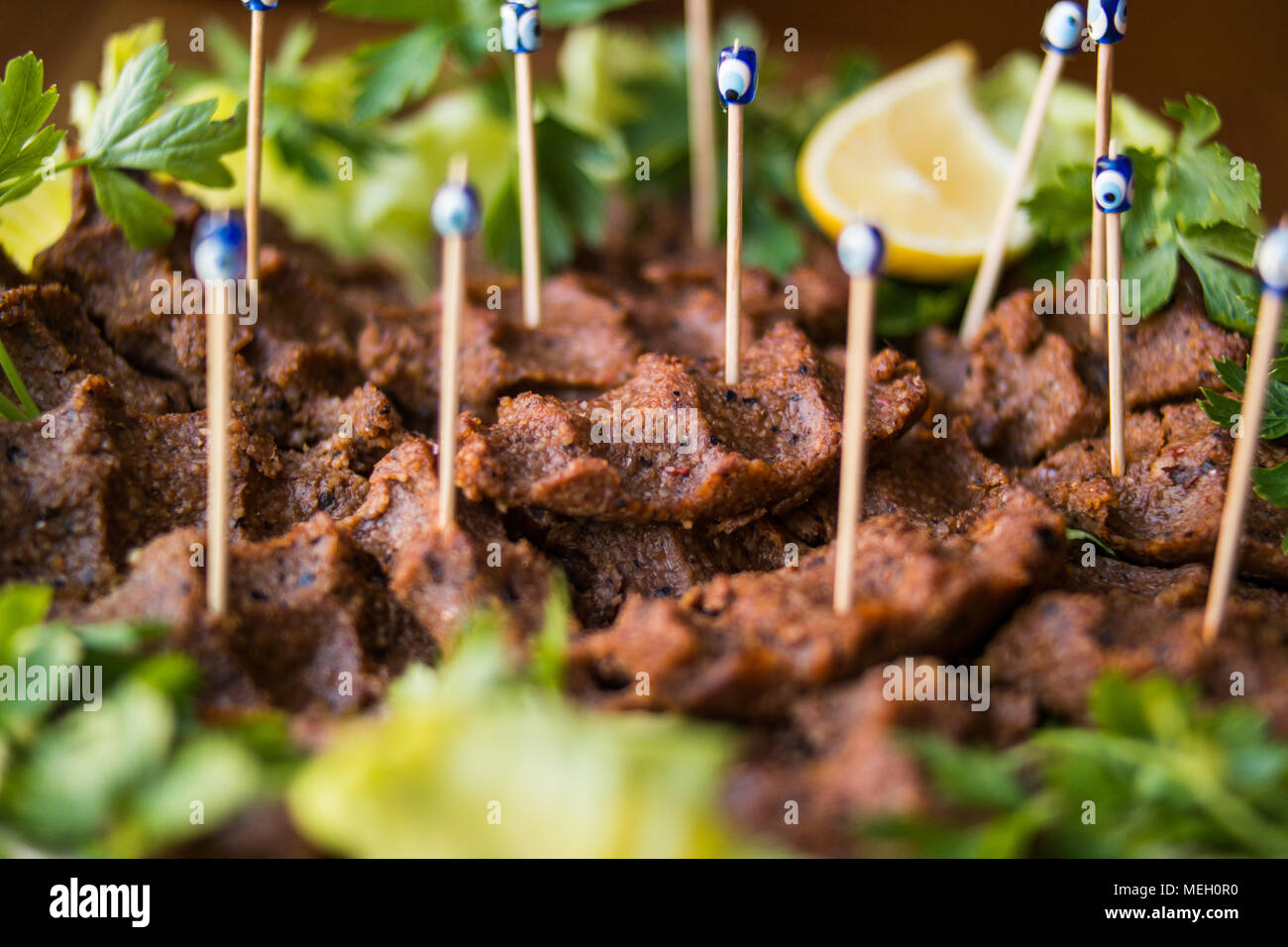 Turkish Food Cig Kofte with lemon, lettuce and parsley on silver tray ...