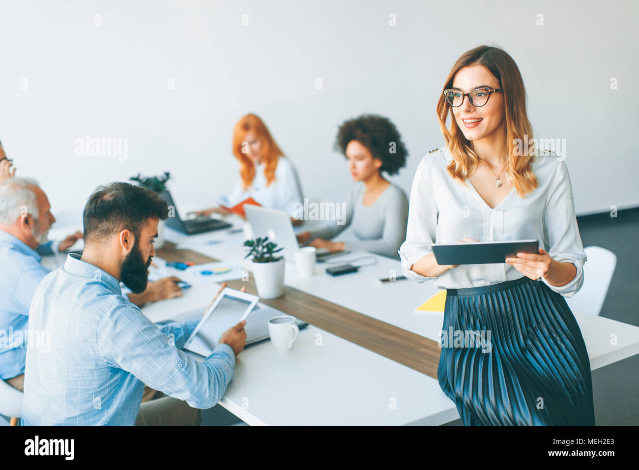 Young attractive female manager working on digital tablet while ...