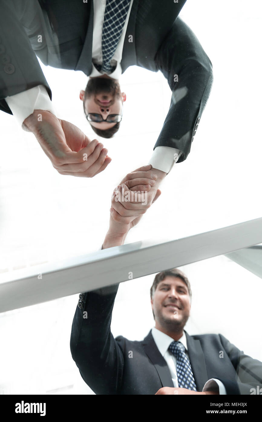 View from below. From behind the glass. Handshake of business partners ...