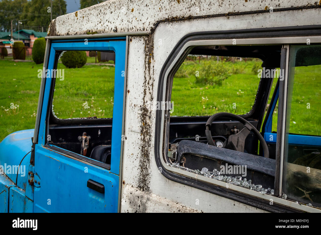 Abandoned vintage car blue lush green grass no window panes broken glass Stock Photo - Alamy