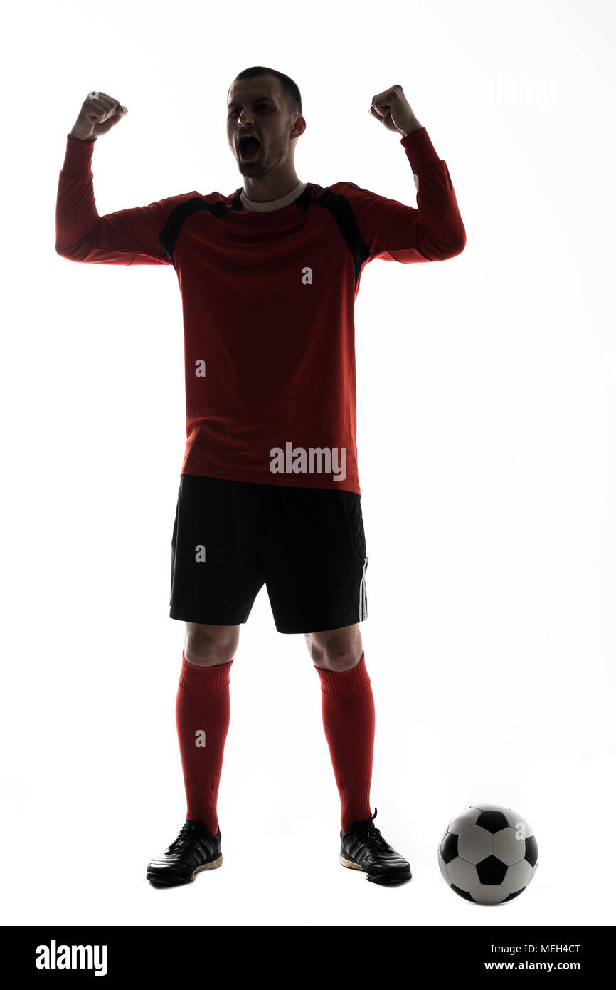 Silhouette of young football player victory scream arms up with soccer ...