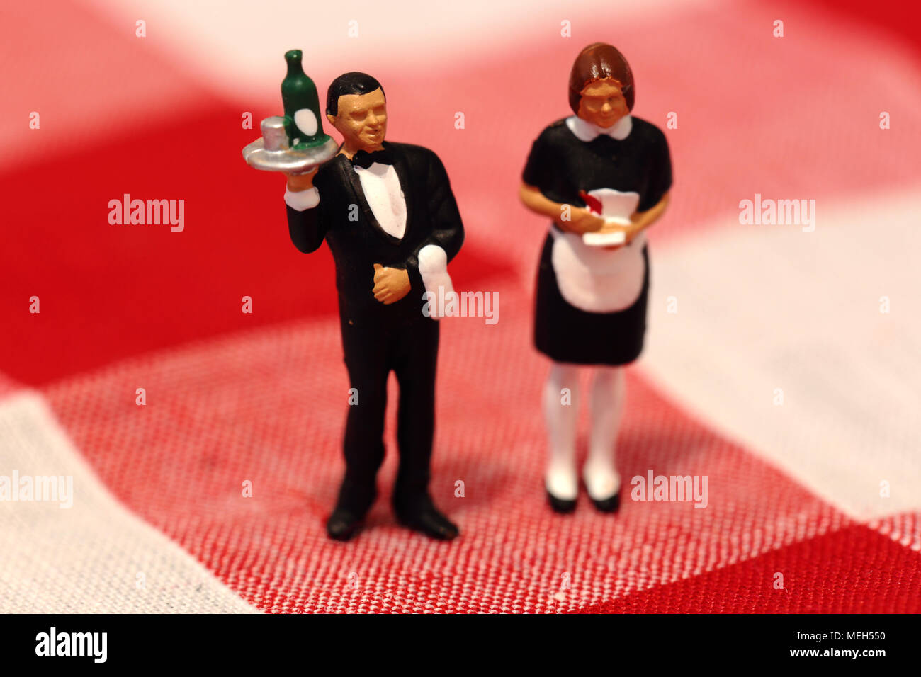 Miniature scale model waiter and waitress on a gingham tablecloth ...