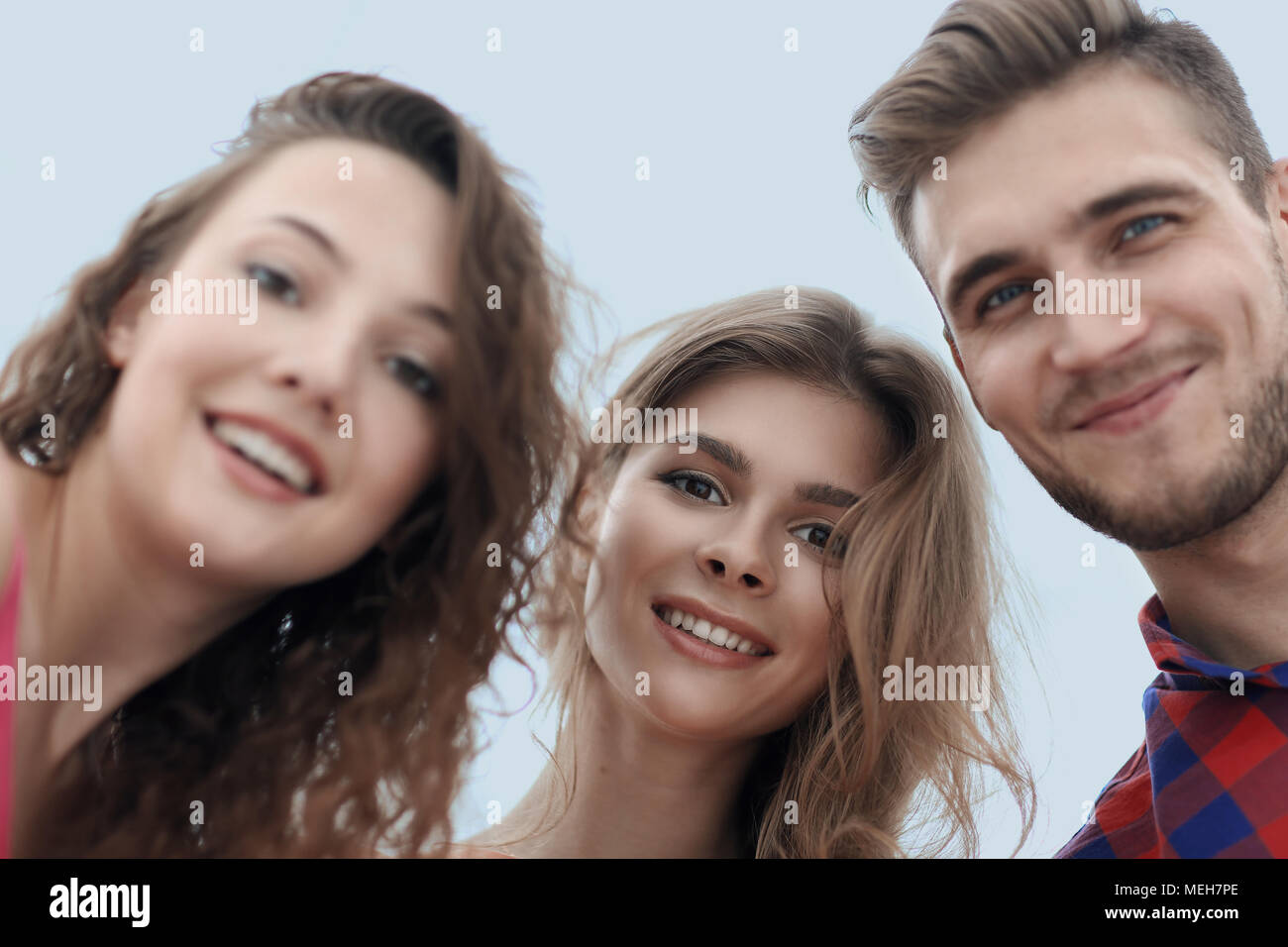 closeup of three young people smiling on white background Stock Photo ...