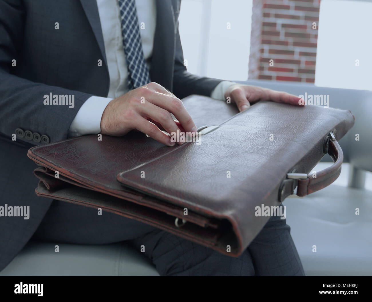 businessman's hand with suitecase in a modern office Stock Photo - Alamy