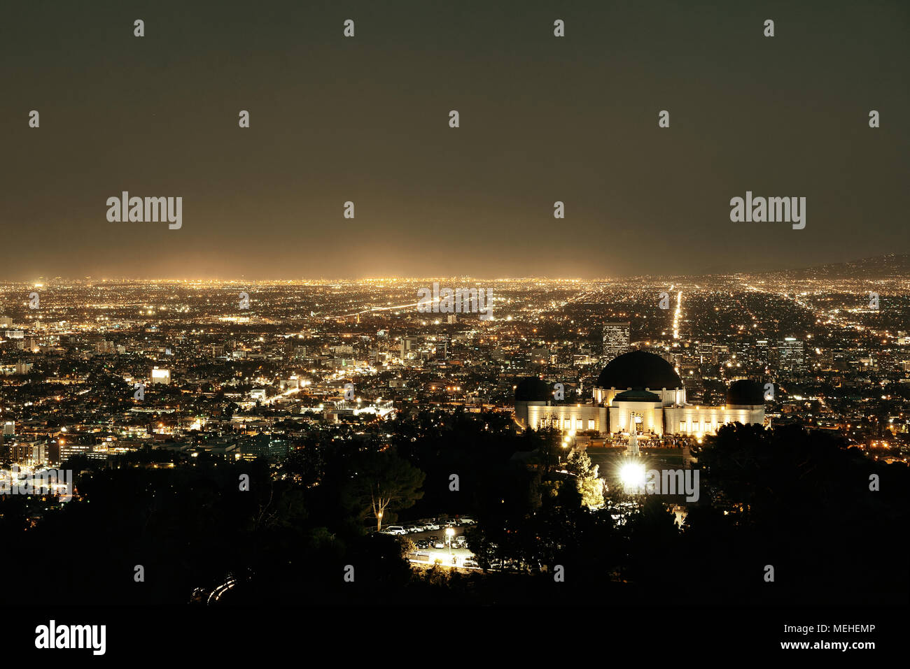 Los Angeles at night with urban buildings and Griffith Observatory ...