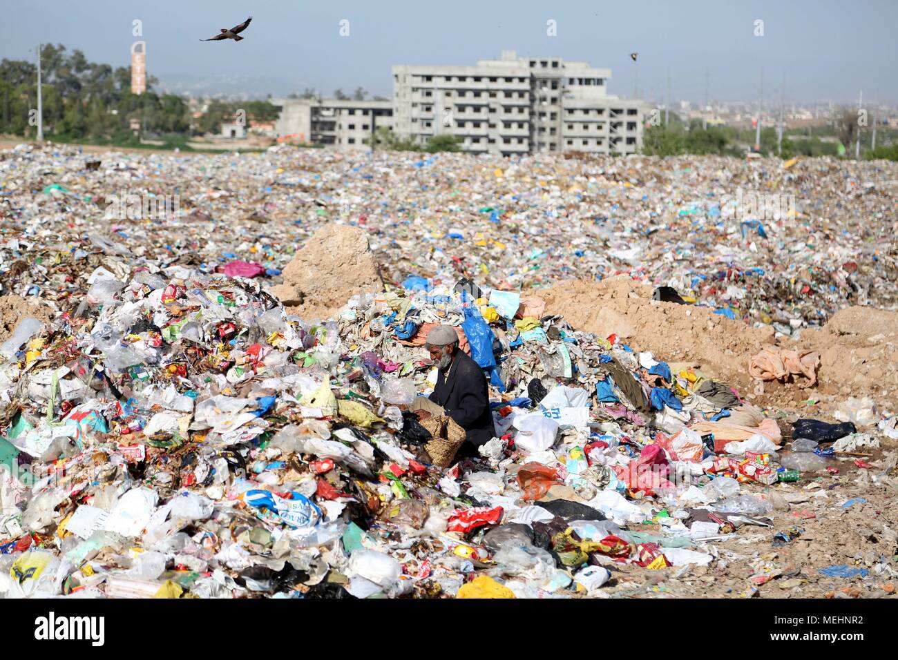 Islamabad. 22nd Apr, 2018. A man collects useable plastic items at a ...