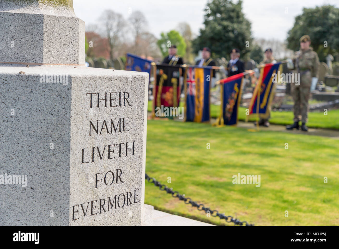 Standard Bearers lower their colours behind the memorial cross in ...