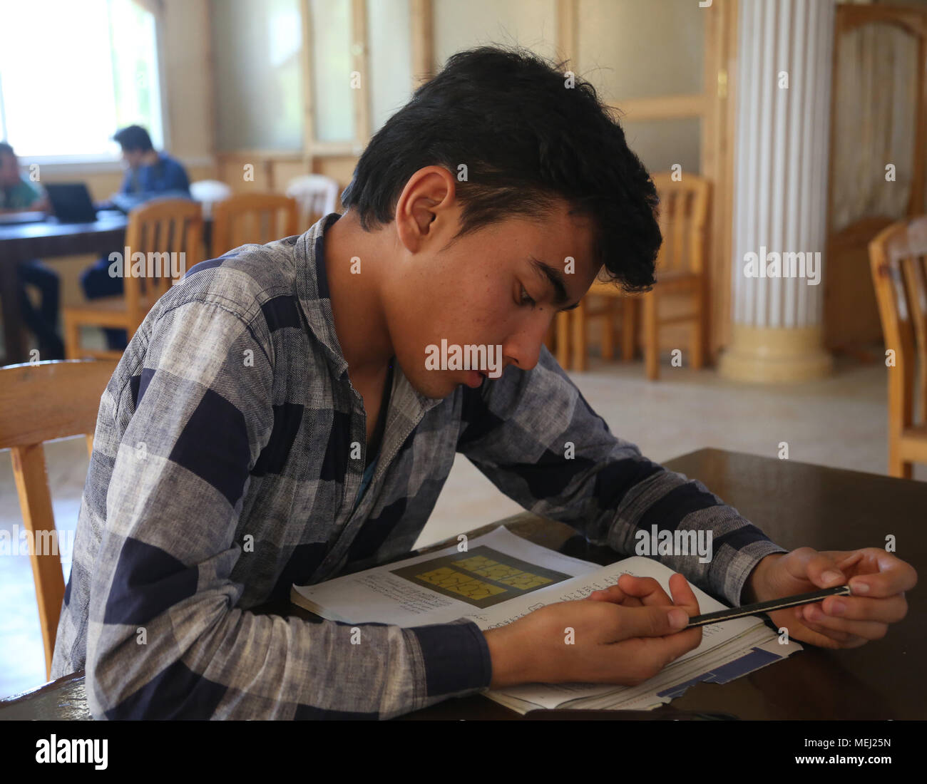 Mazar I Sharif. 23rd Apr, 2018. A student reads a book at a library in ...