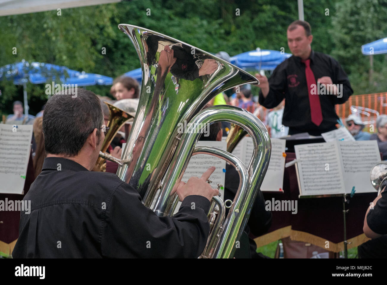 Man plays a tuba in a band performing outside at Canons Park, Harrow ...
