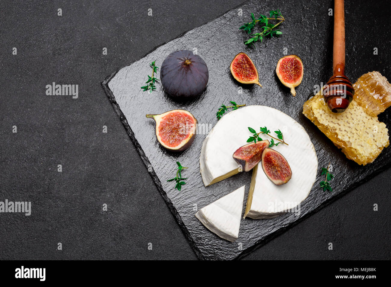 Camembert cheese and cut a slice on stone serving board Stock Photo - Alamy
