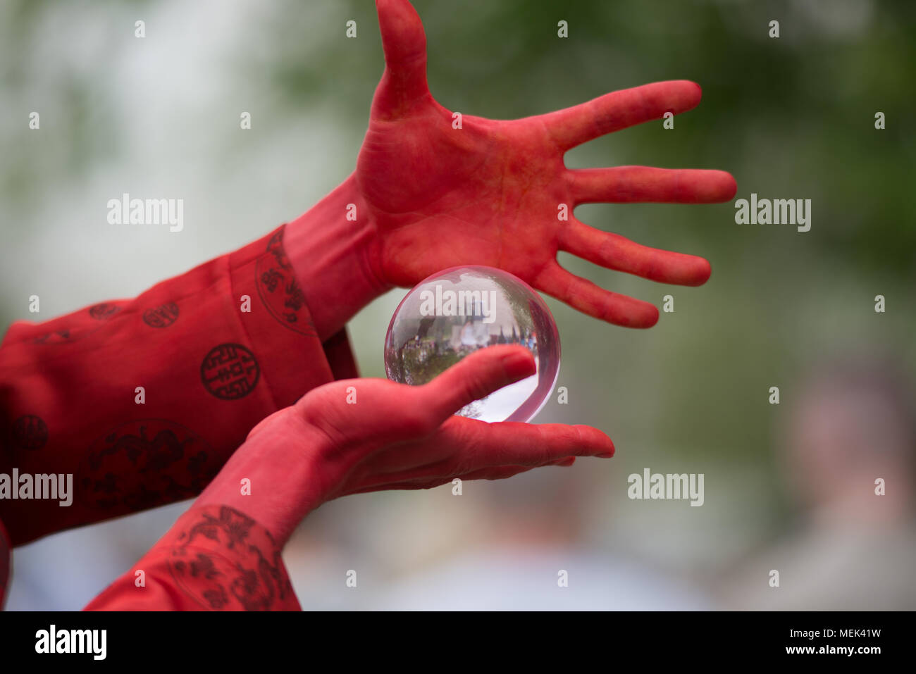 man with red hands dressed as the devil holds and plays with an ...
