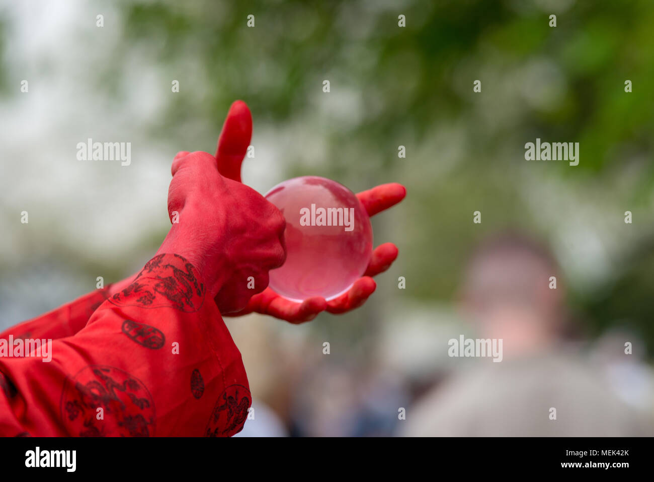 man with red hands dressed as the devil holds and plays with an ...