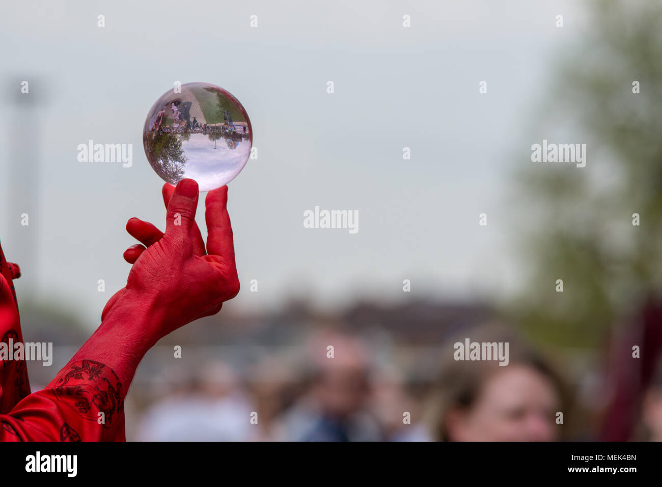 man with red hands dressed as the devil holds and plays with an ...