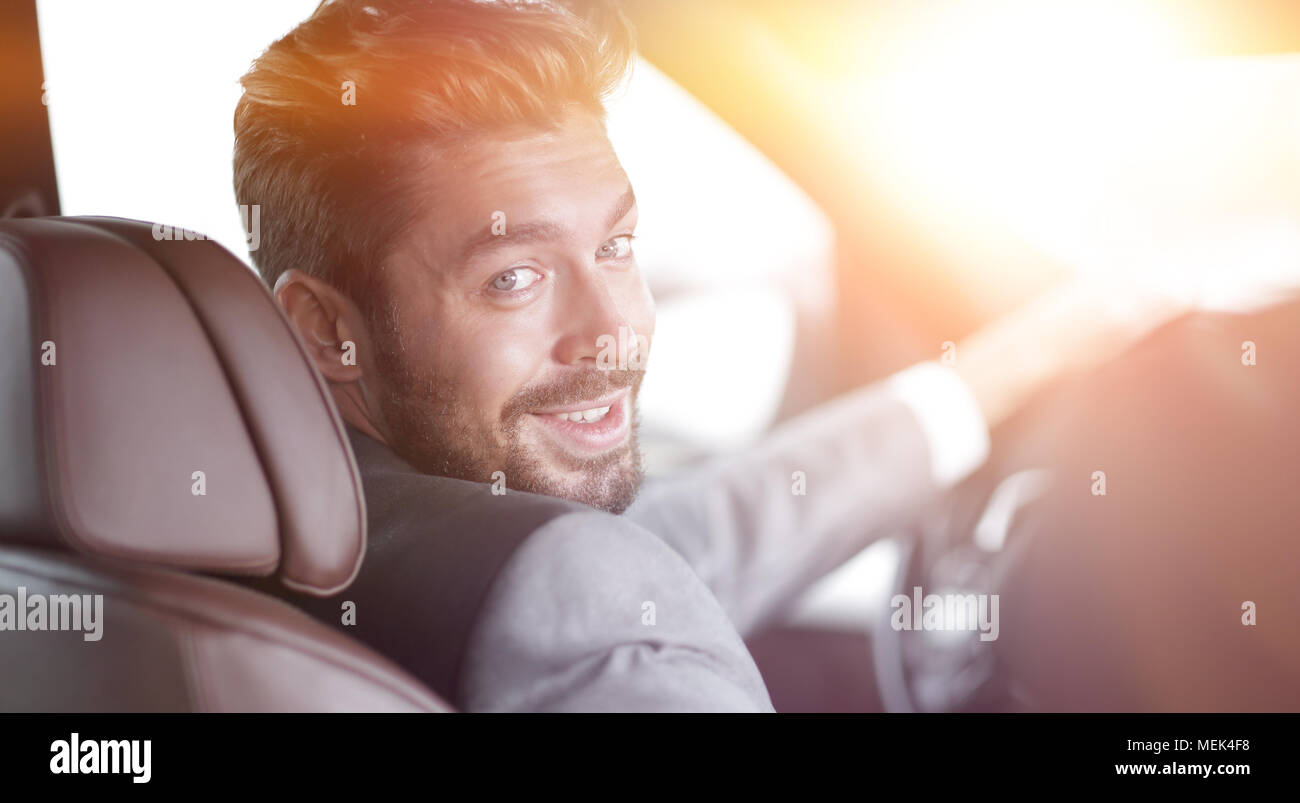 rear view, young man driving his car, looking at camera Stock Photo - Alamy
