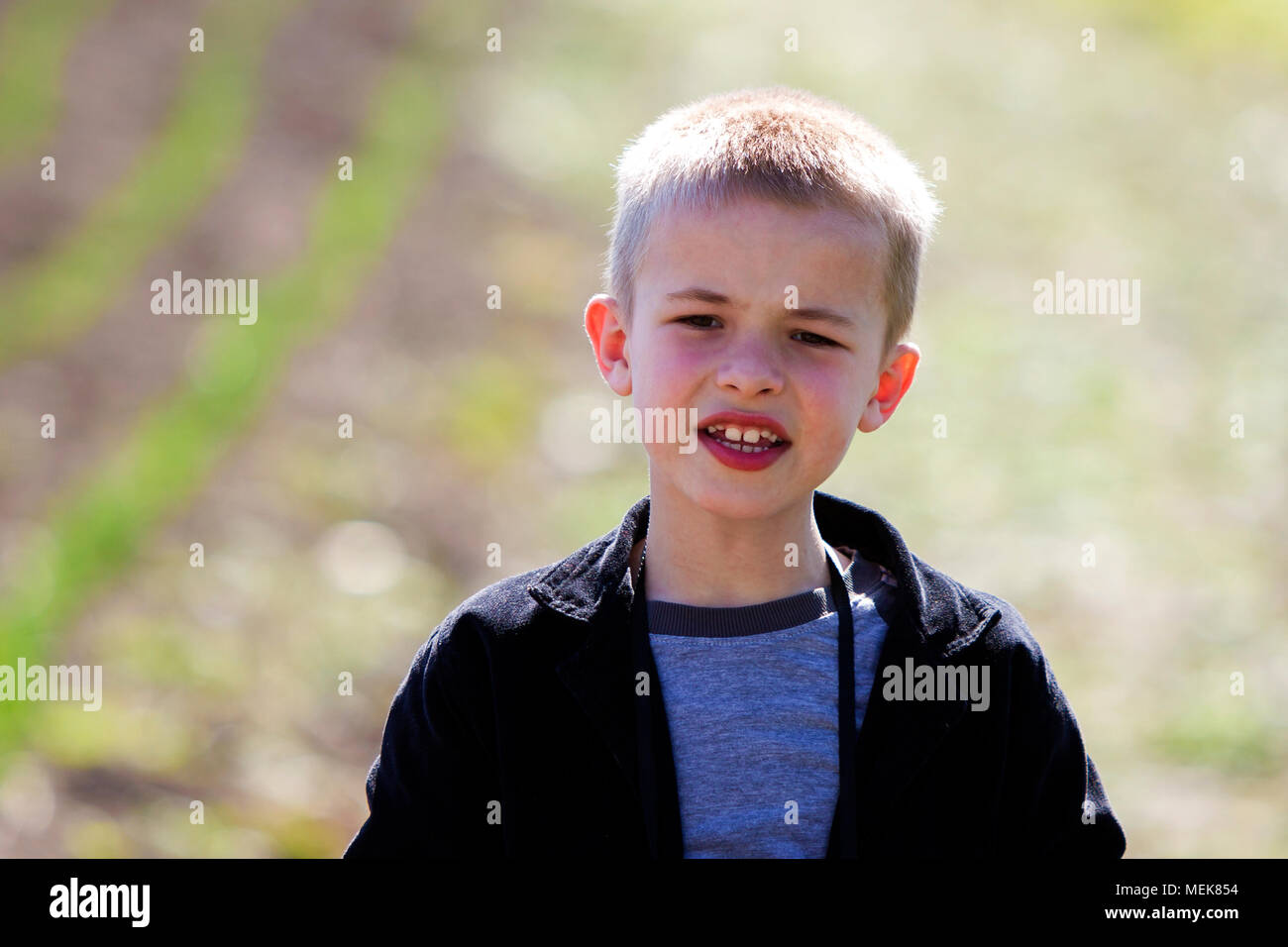 Portrait of little handsome serious cute blond boy with funny uneven ...