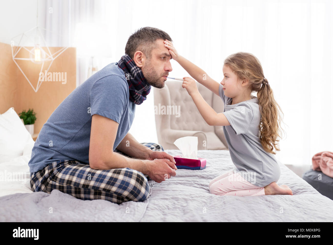Concentrated girl treating her sick father Stock Photo - Alamy