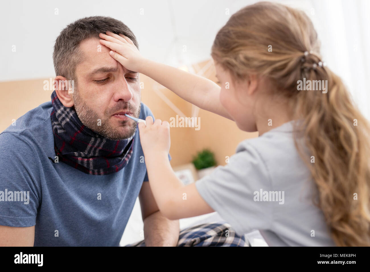 Determined girl treating her sick father Stock Photo - Alamy