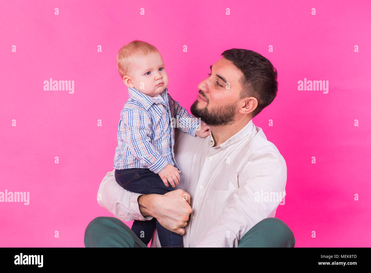 Happy father with his baby son on pink background Stock Photo - Alamy