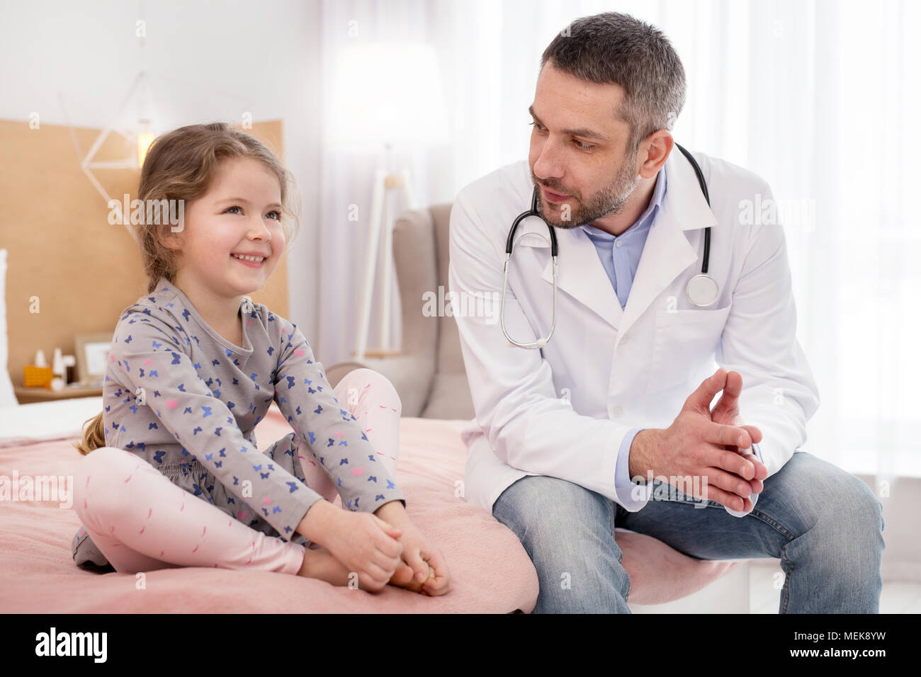 Alert doctor visiting a little girl Stock Photo - Alamy