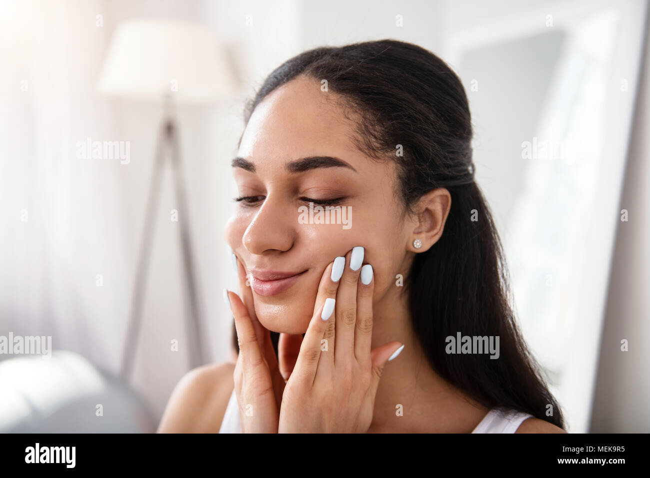 Pleasant young woman stretching skin of her cheeks Stock Photo - Alamy