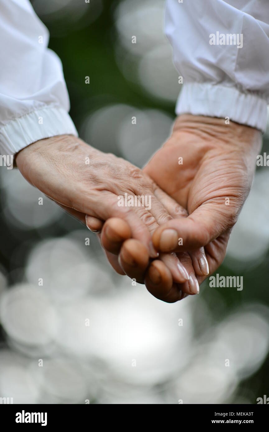 Elderly couple holding hands Stock Photo - Alamy