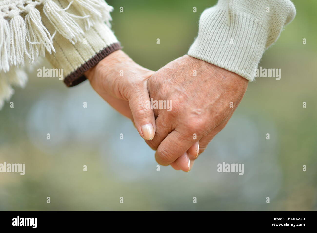 Elderly couple holding hands Stock Photo - Alamy
