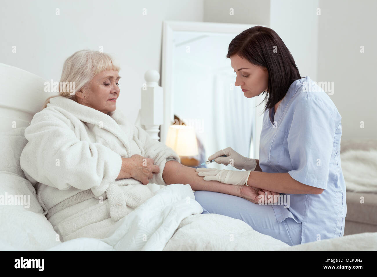 Concentrated nice nurse making injection Stock Photo - Alamy