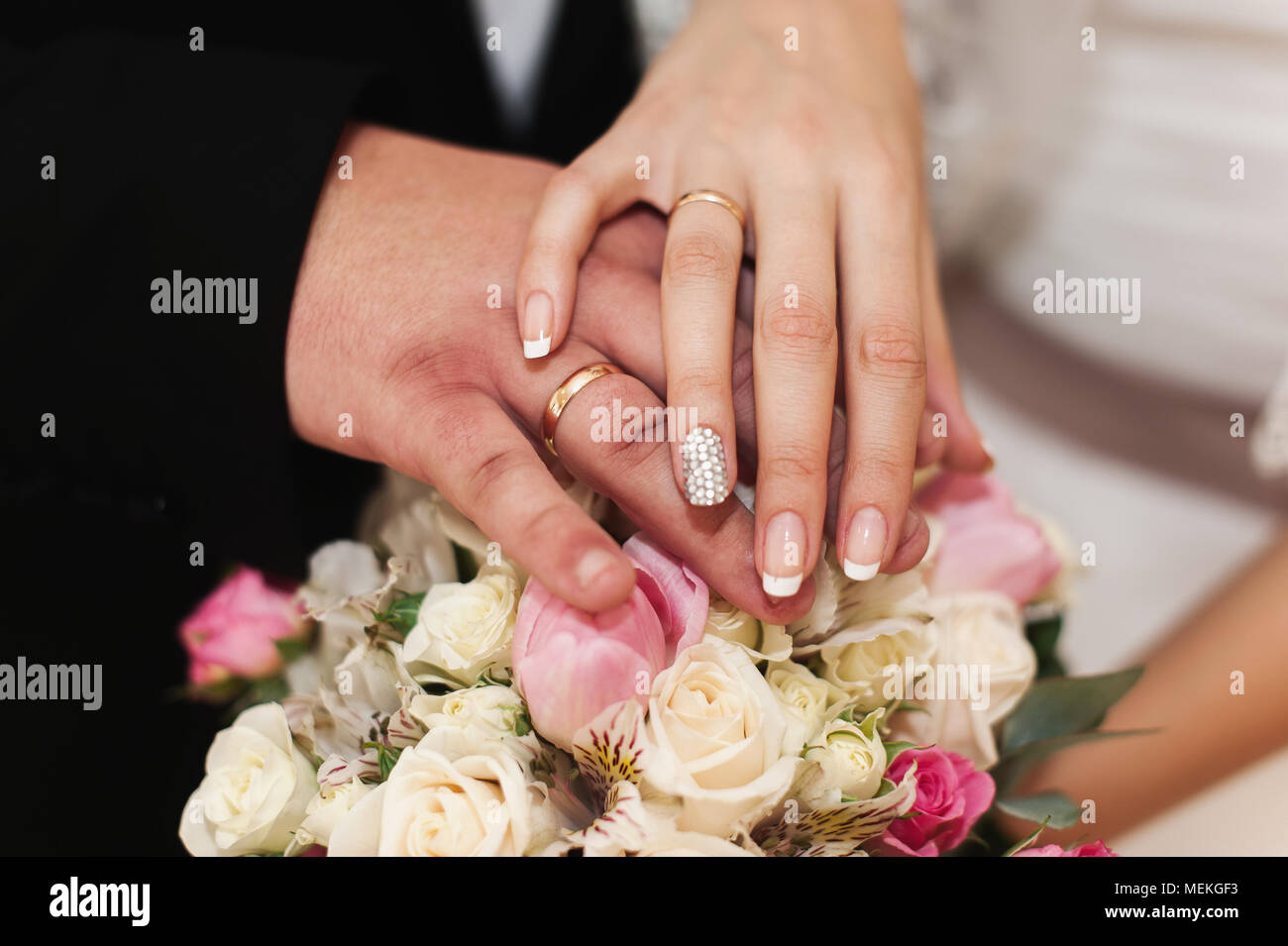 Hands of newlyweds with rings on unusual wedding bouquet Stock Photo ...