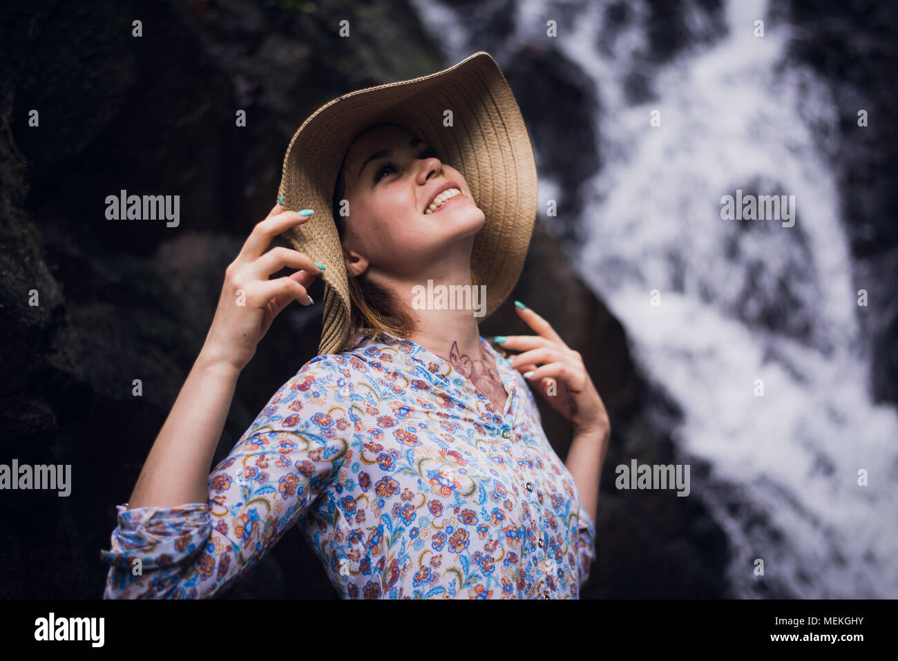 Cute woman with a hat posing by the forest waterfalls Stock Photo - Alamy