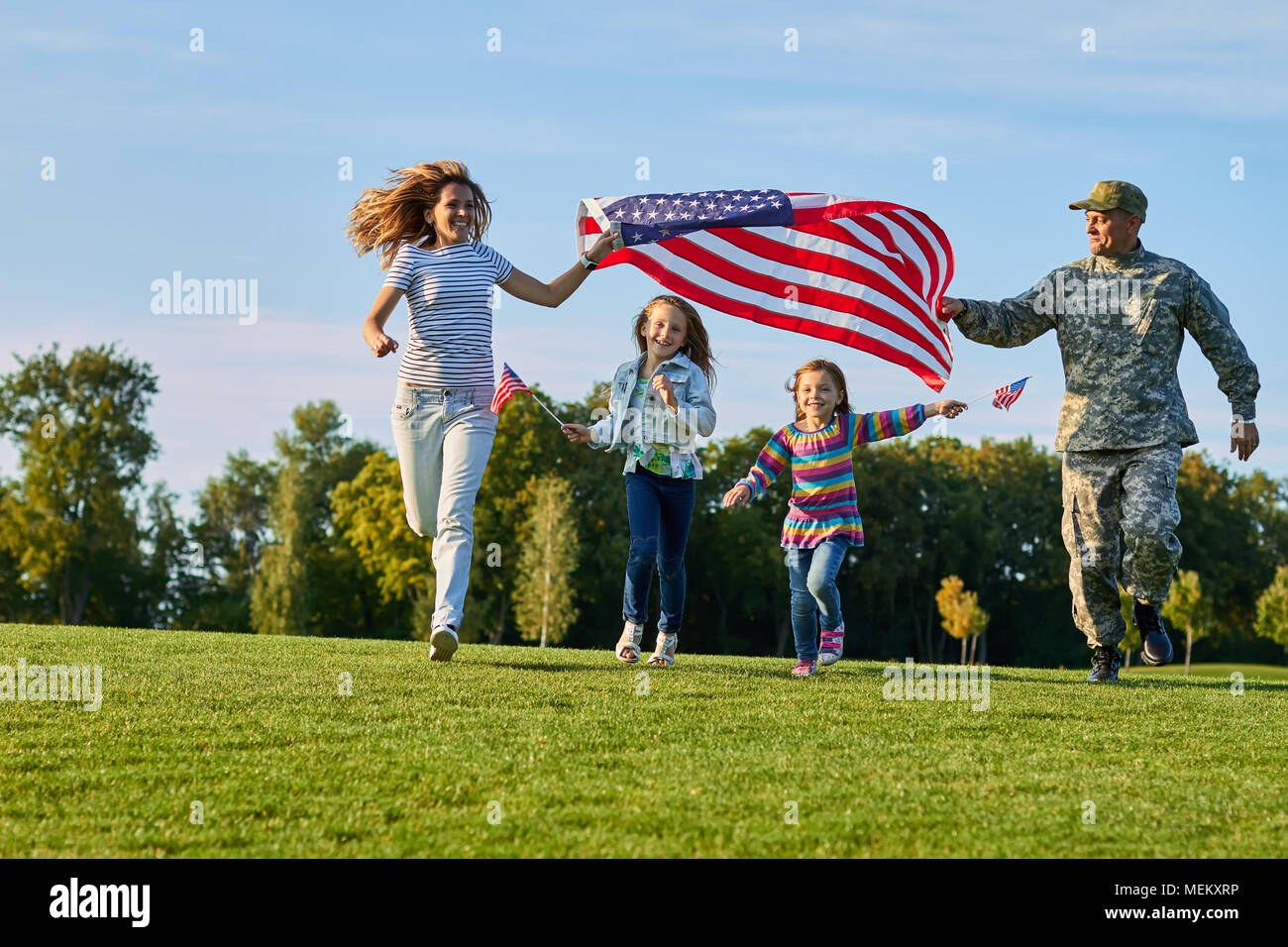 Shot of patriotic family running with flag Stock Photo - Alamy
