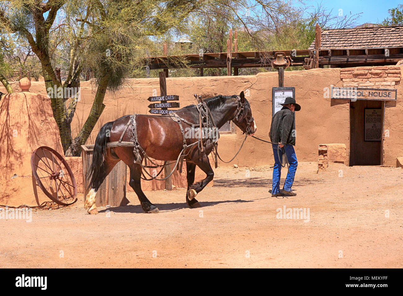 Old Cowboy leading his horse to the stable building at the Old Tucson ...