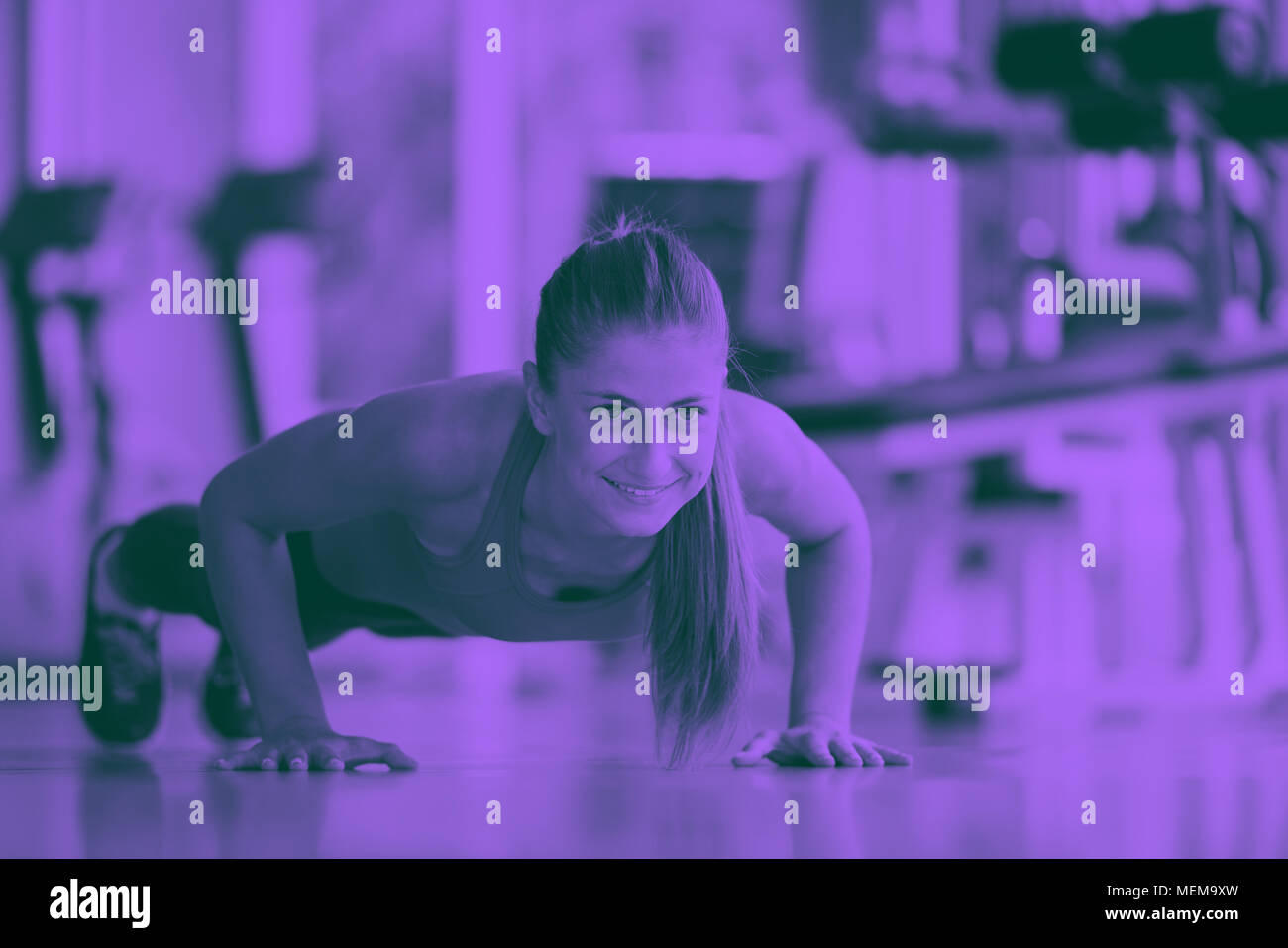 Gorgeous blonde woman warming up and doing some push ups a the gym duo ...