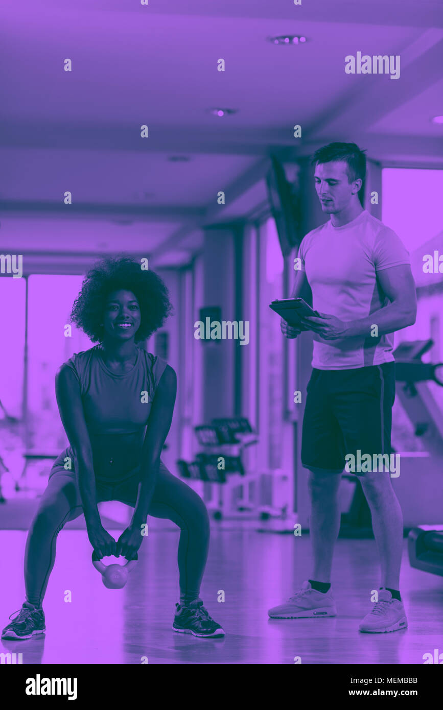 healthy young couple in crossfit gym weights workout with personal ...