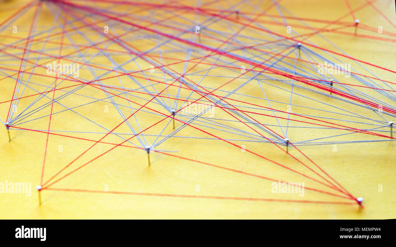 Red and grey rope strings connected with nails on yellow background ...