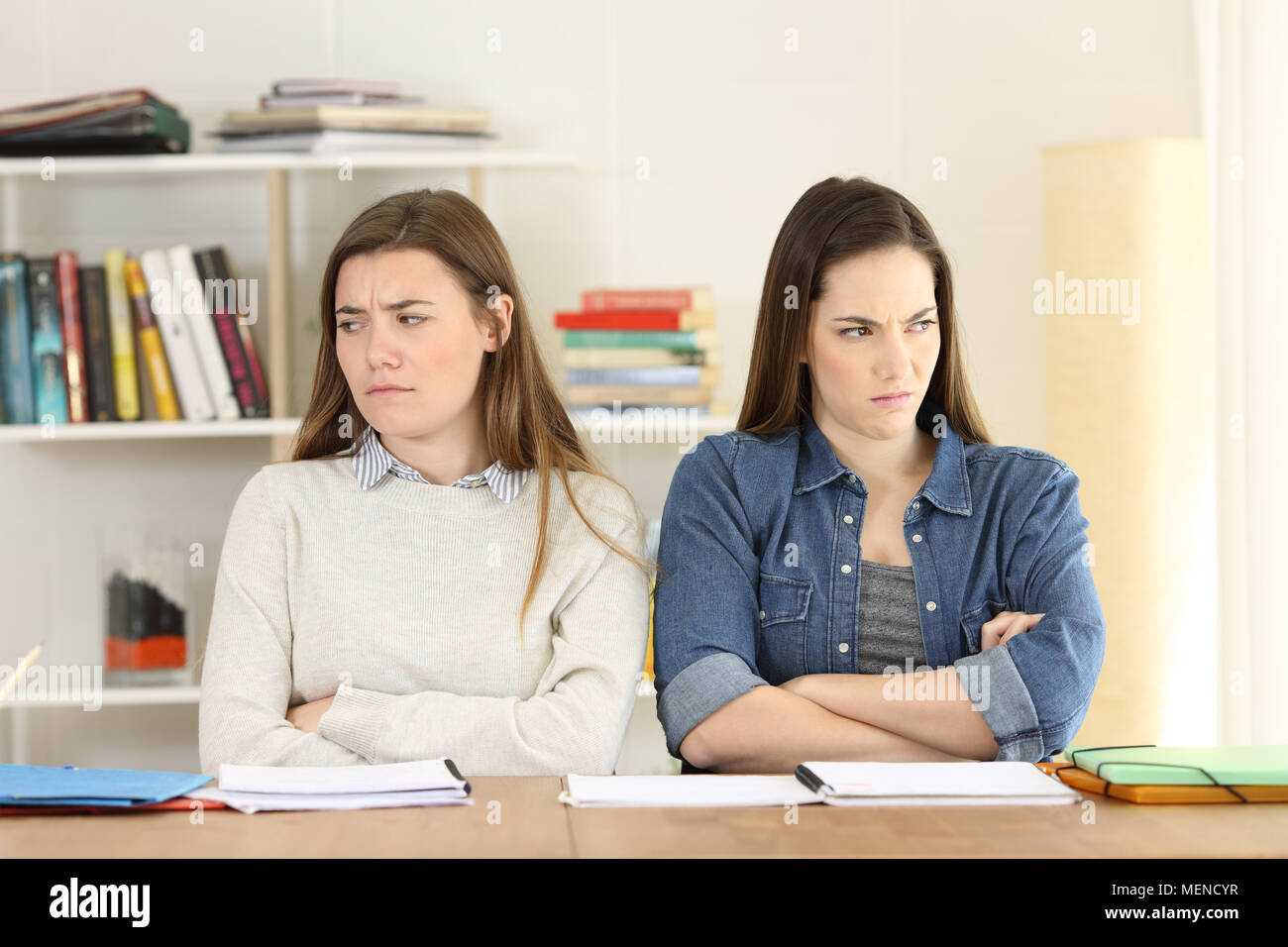 Front view of two angry students looking ignoring each other at home ...