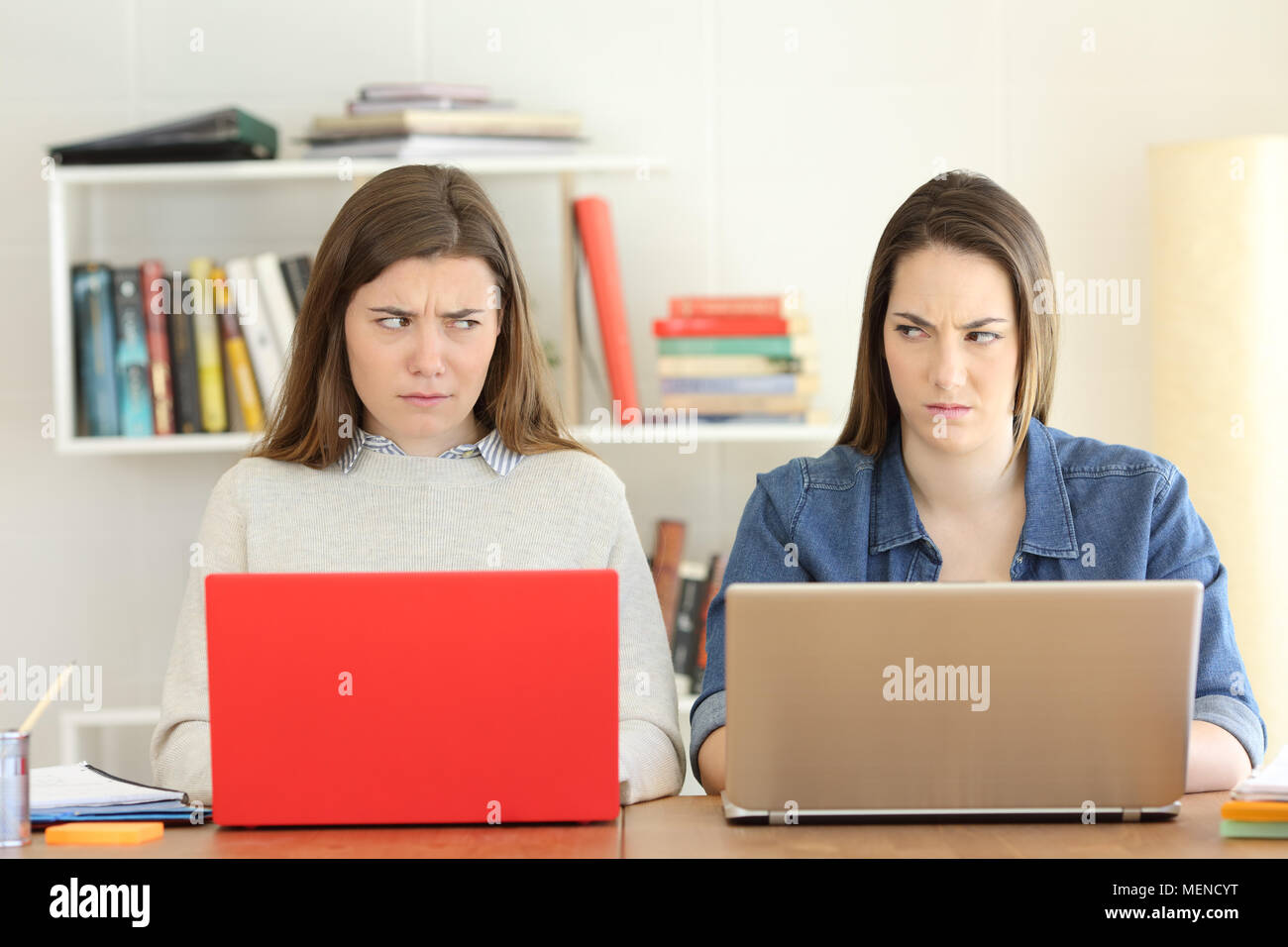 Front view portrait of two angry students studying looking each other ...