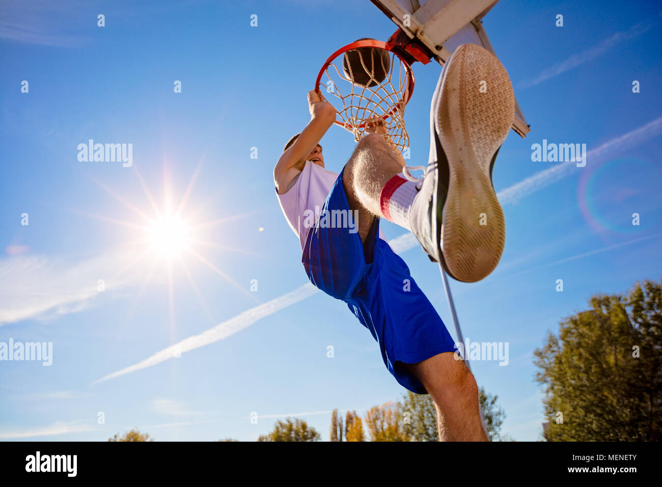 Slam Dunk. Side view of young basketball player making slam dunk Stock ...