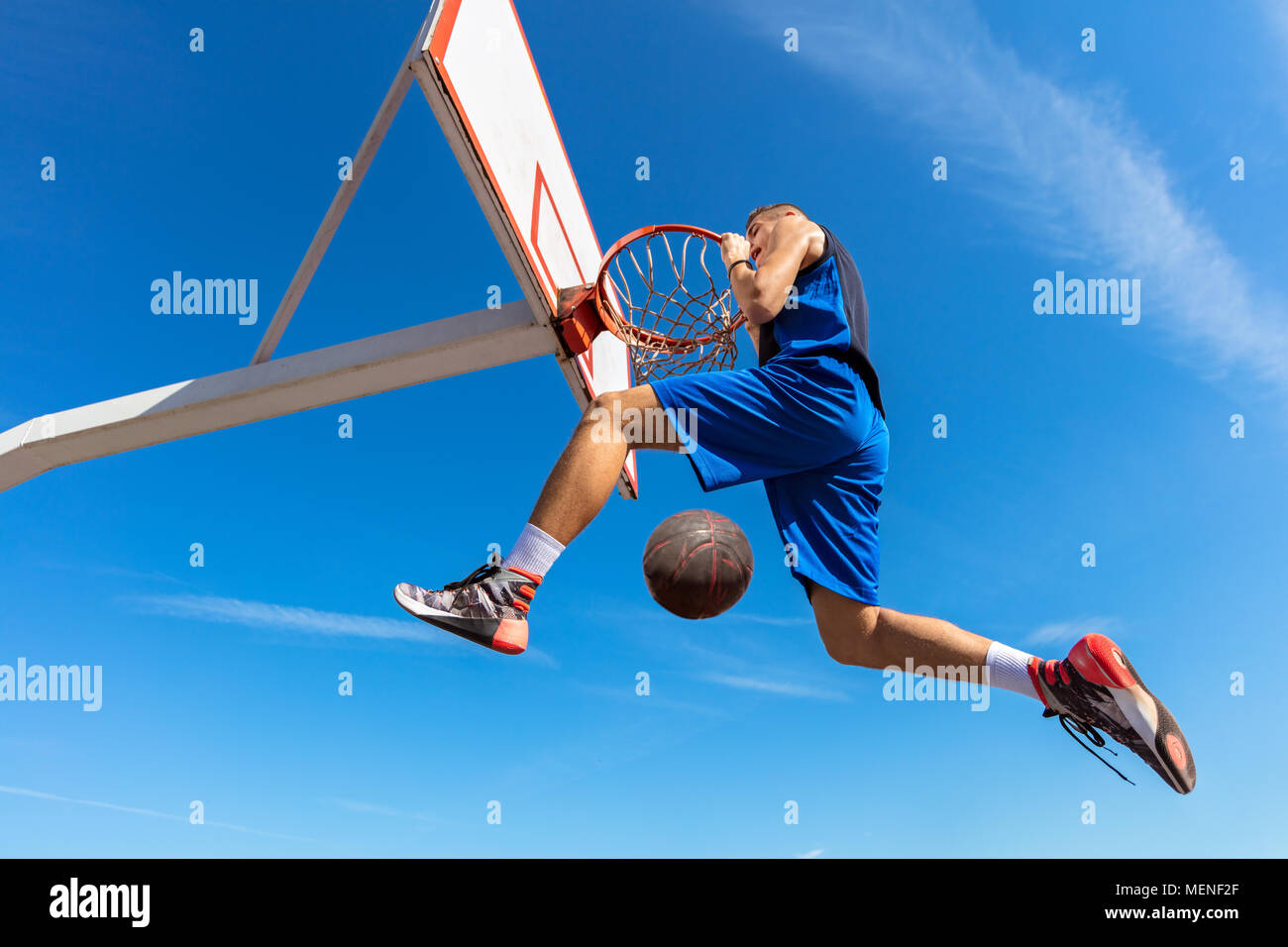 Slam Dunk. Side view of young basketball player making slam dunk Stock ...