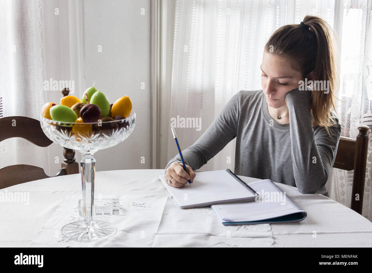 A teenager girl studying at home, hand writing on a notebook Stock ...