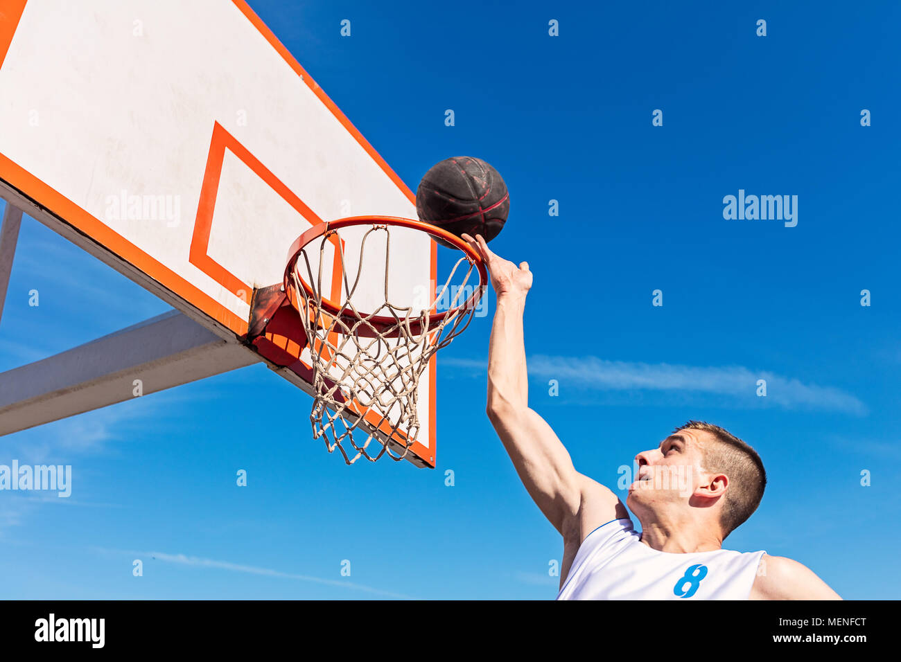Slam Dunk. Side view of young basketball player making slam dunk Stock ...