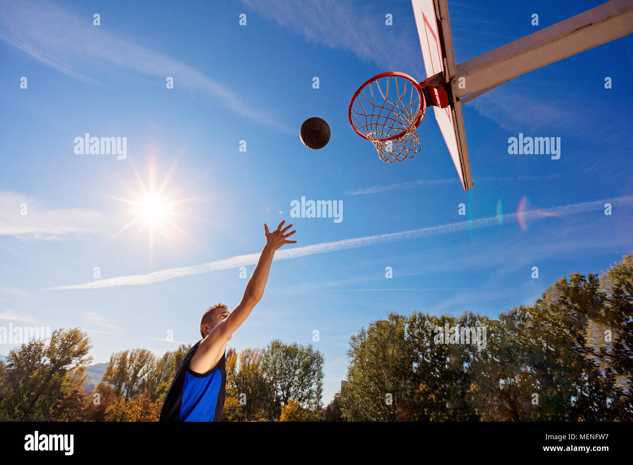 Slam Dunk. Side view of young basketball player making slam dunk Stock ...