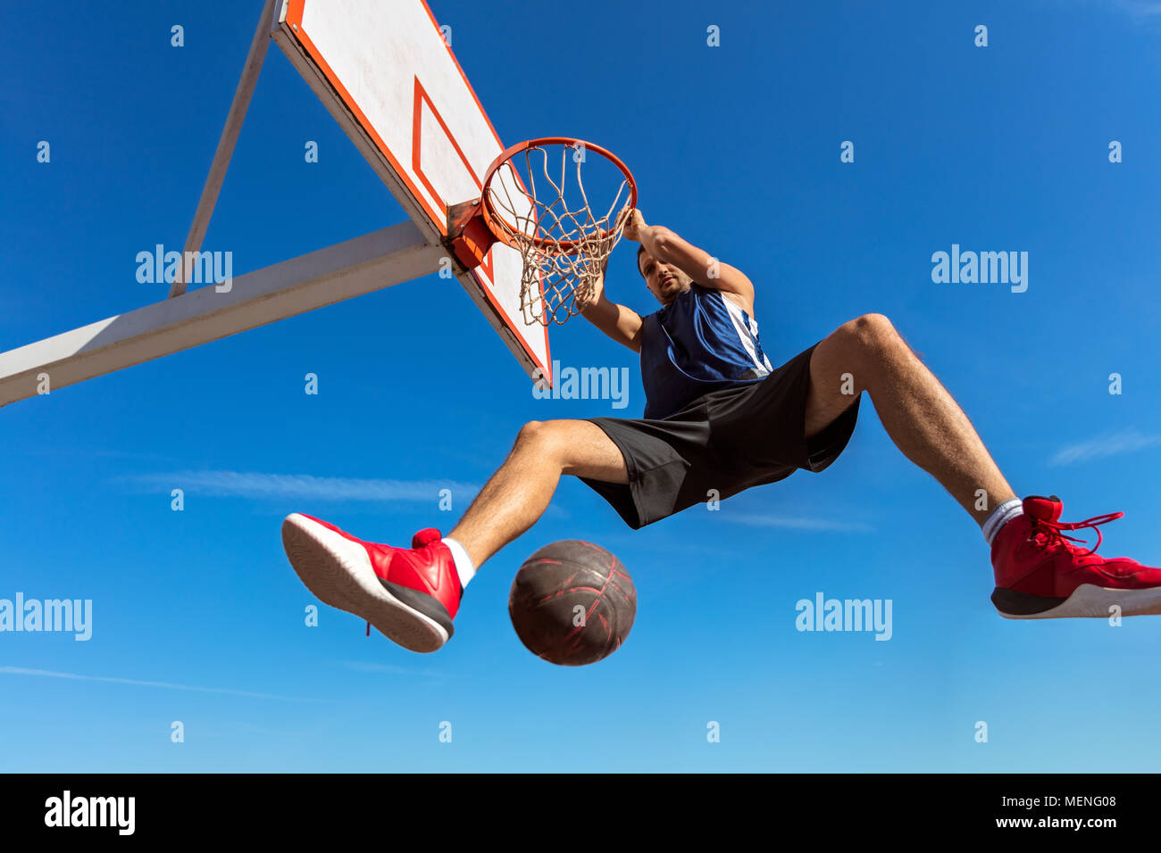 Slam Dunk. Side view of young basketball player making slam dunk Stock ...