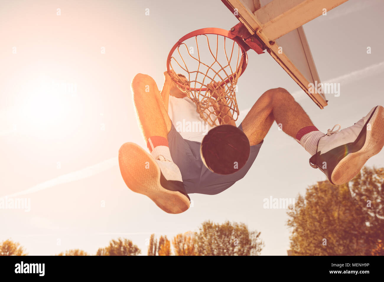 Street basketball player performing power slum dunk Stock Photo - Alamy