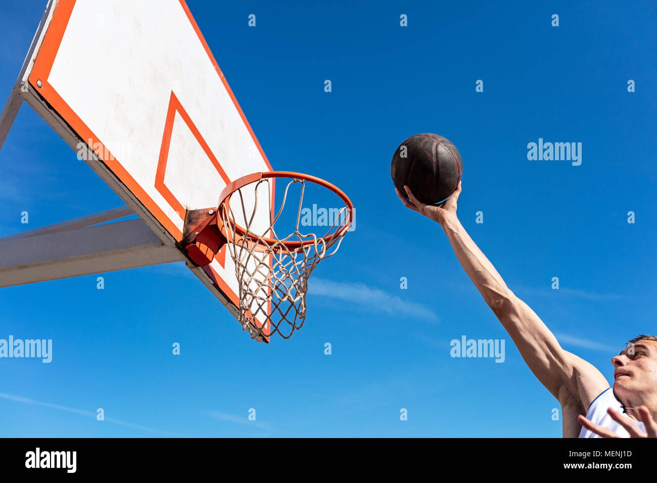 Slam Dunk. Side view of young basketball player making slam dunk Stock ...