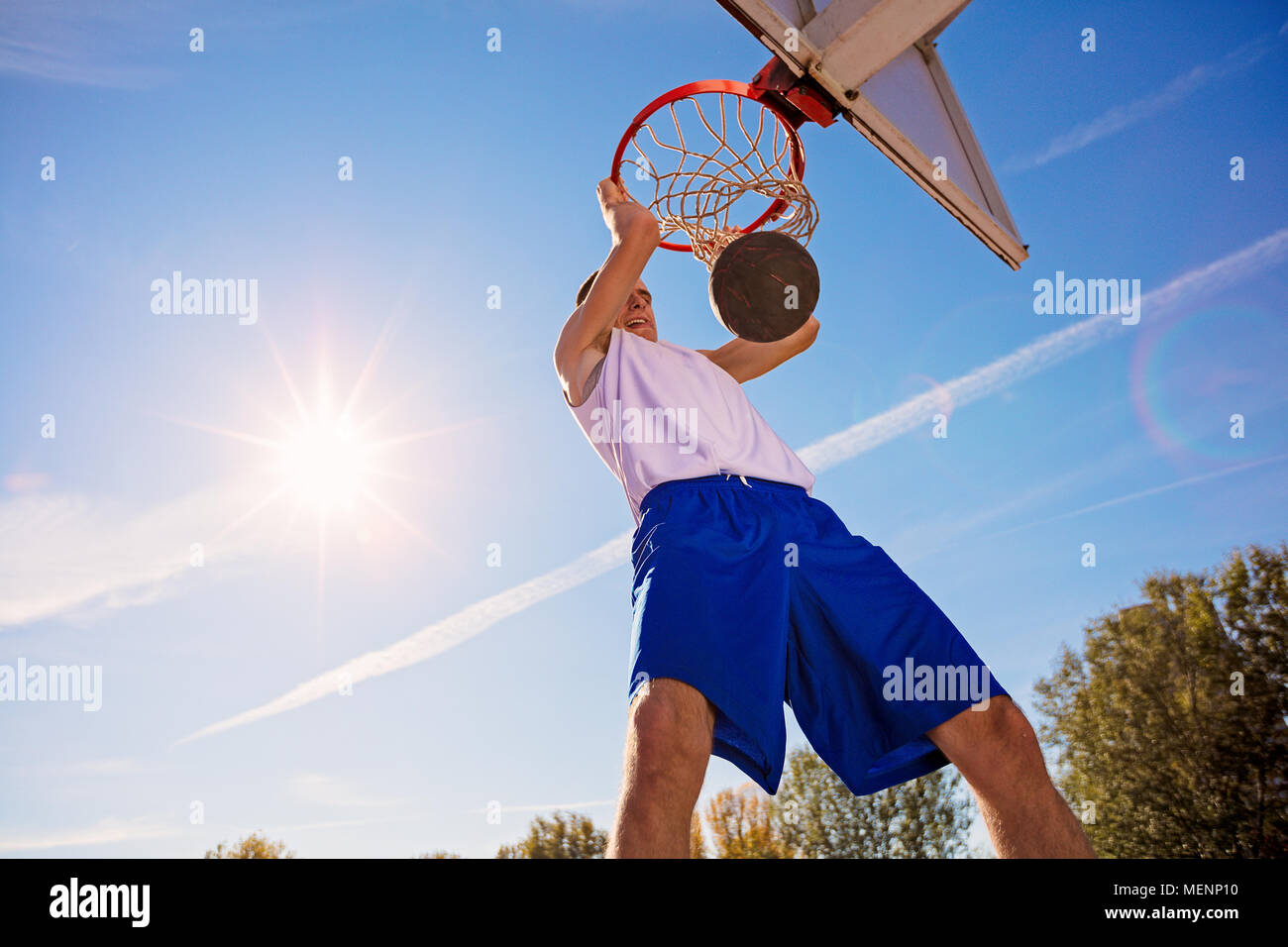 Slam Dunk. Side view of young basketball player making slam dunk Stock ...